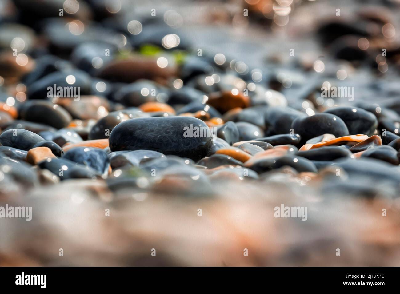 Shiny pebbles on the beach illuminated by the sun, twinkling lights ...