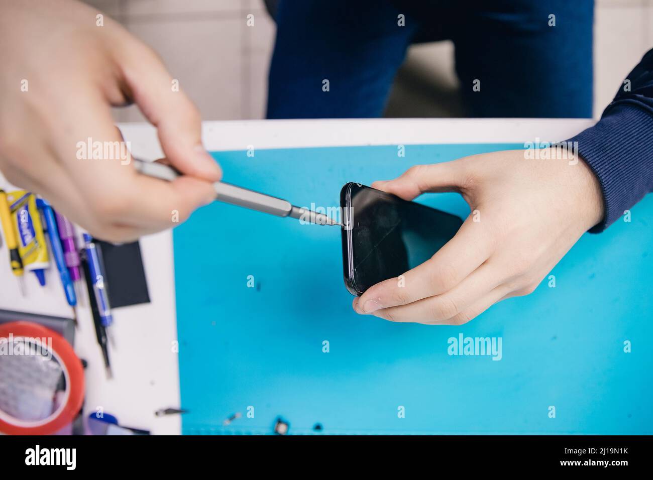 Repair modern mobile phone, master disassembles case to replace broken ...