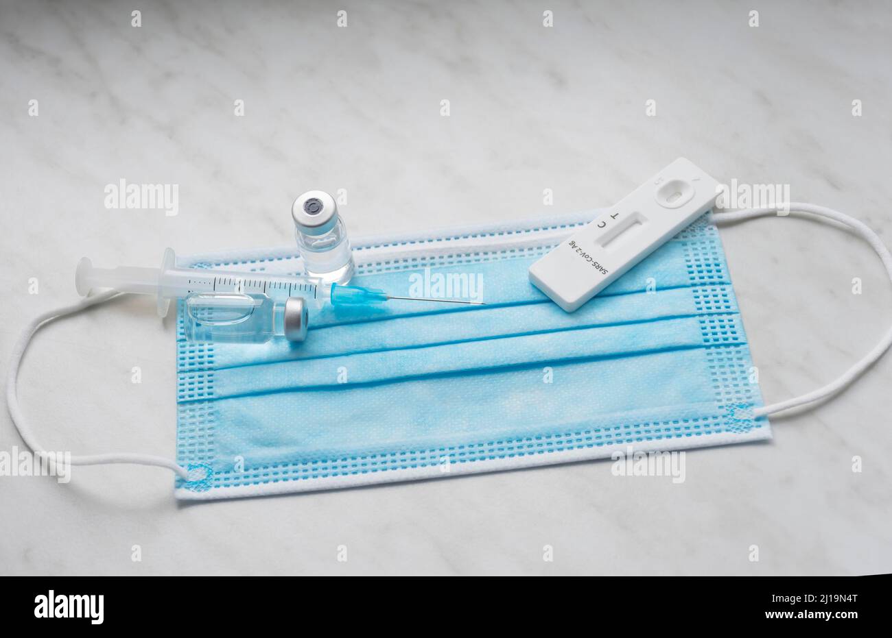 Medical mask, antigen test, vaccine bottles and syringe used for ...