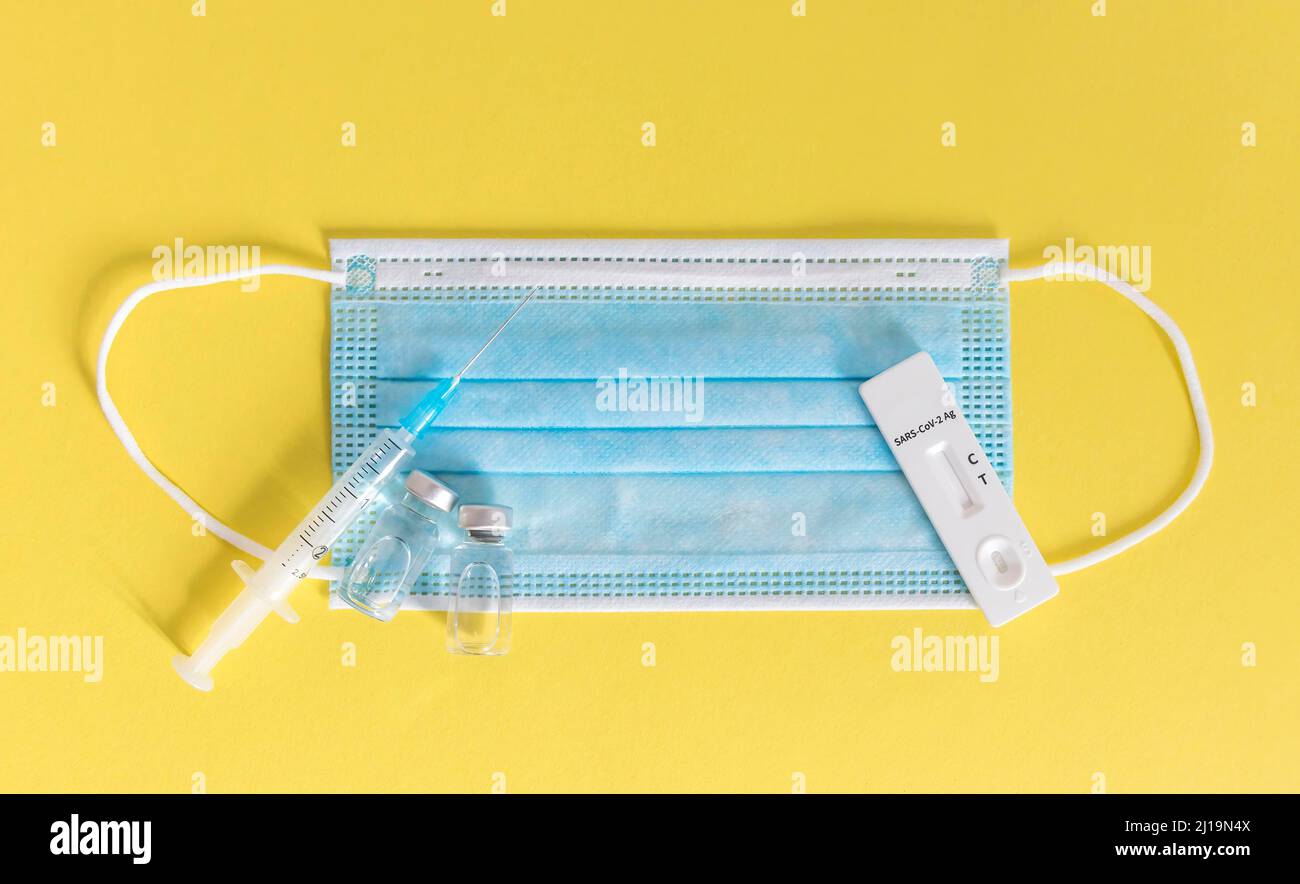 Medical mask, antigen test, vaccine bottles and syringe used for ...