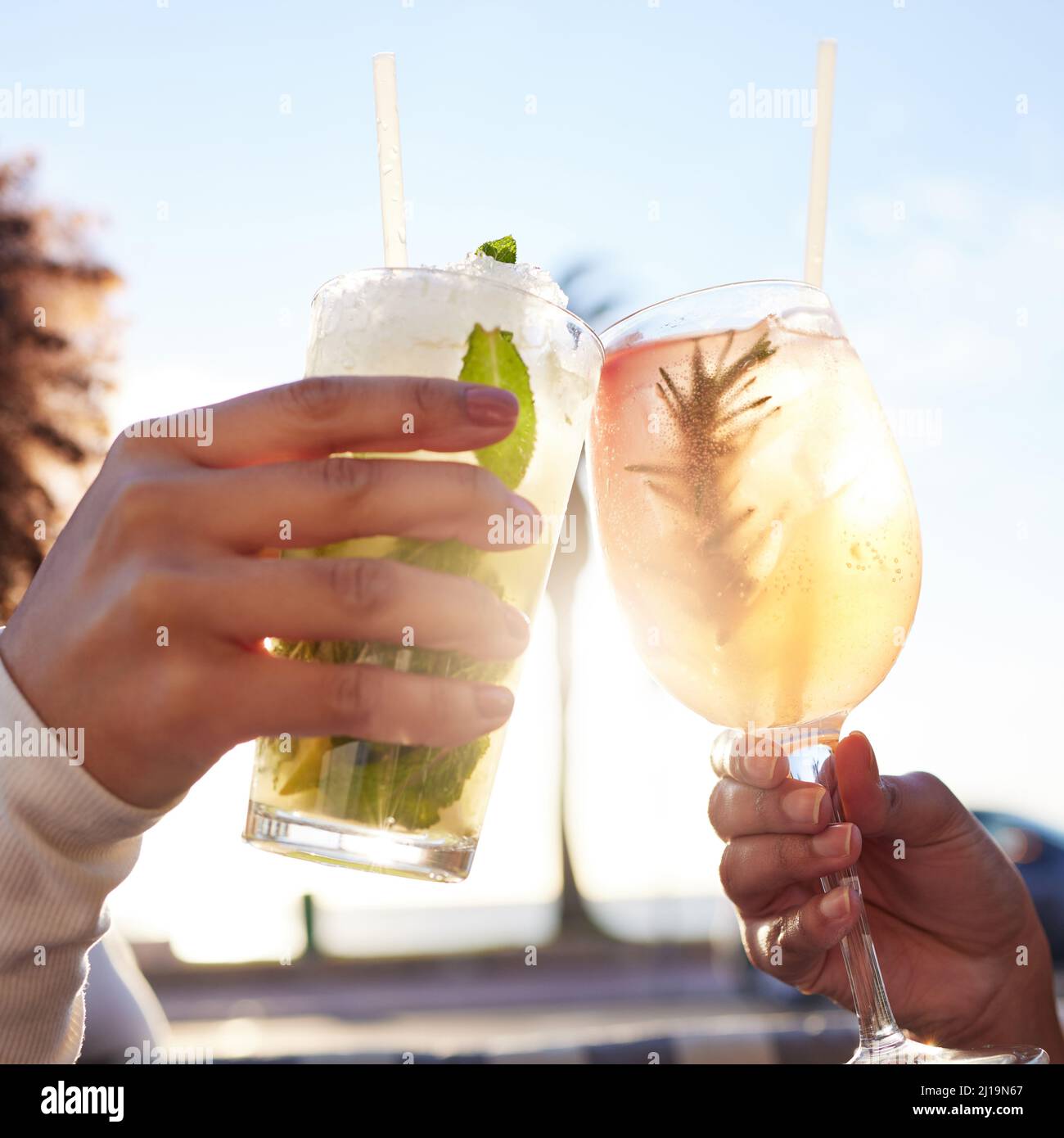 .. Shot of two female friends celebrating with drinks at a bar outside ...
