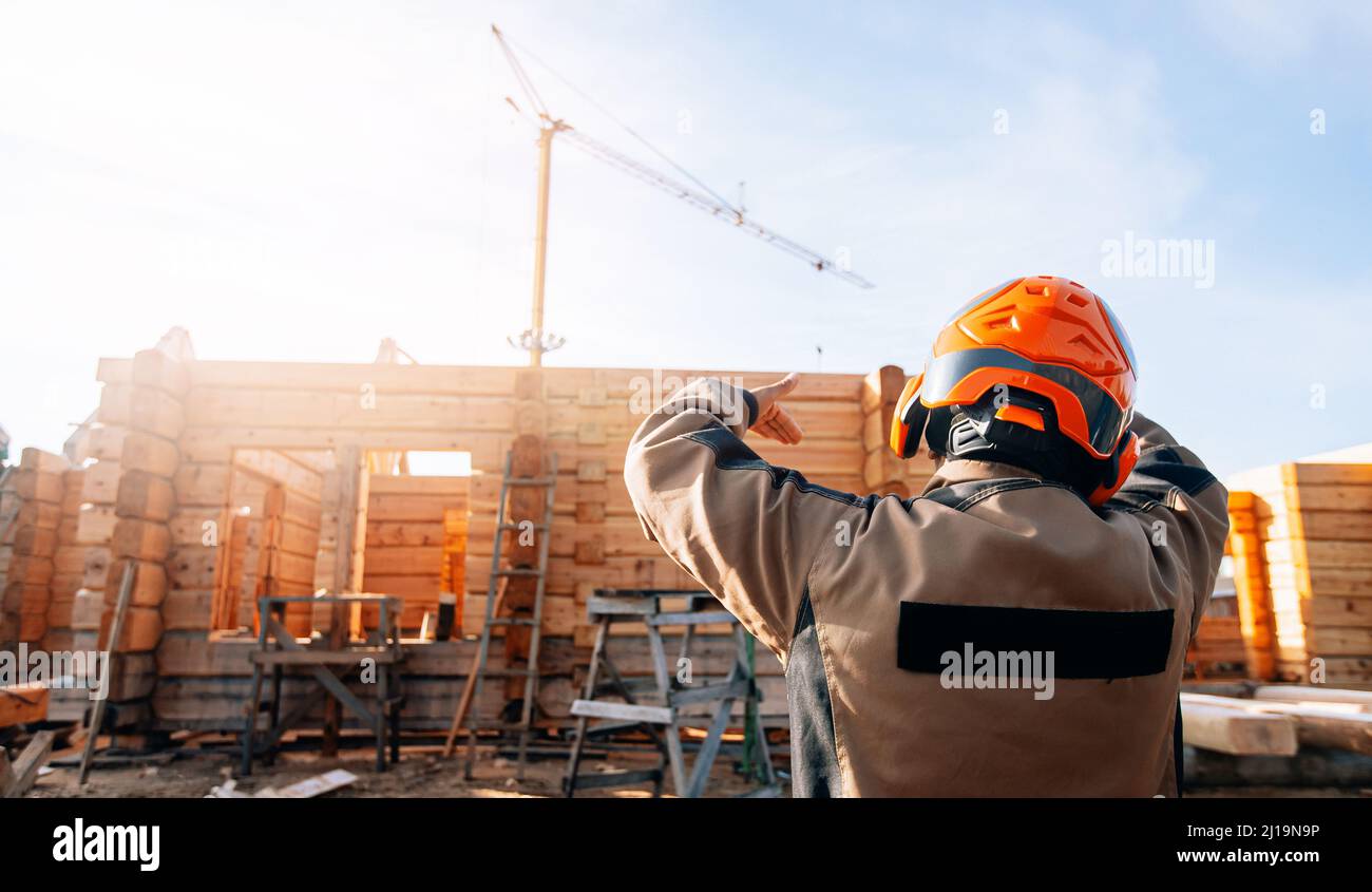 Construction site of wooden cottages houses from log, foreman worker in ...