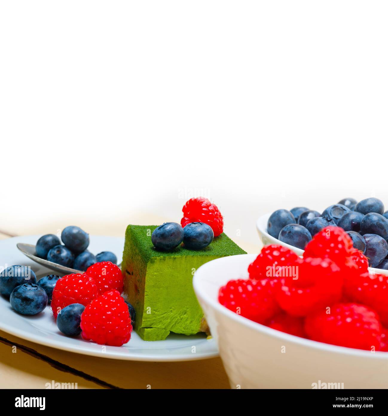 Green tea matcha mousse cake with raspberries and blueberries on top ...