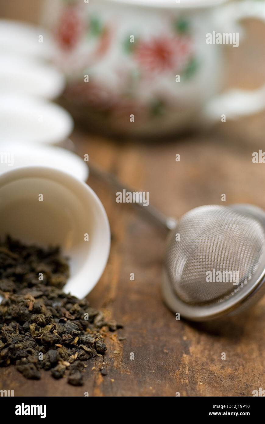 Dry green chinese tea set, with strainer closeup, cups and teapot on ...