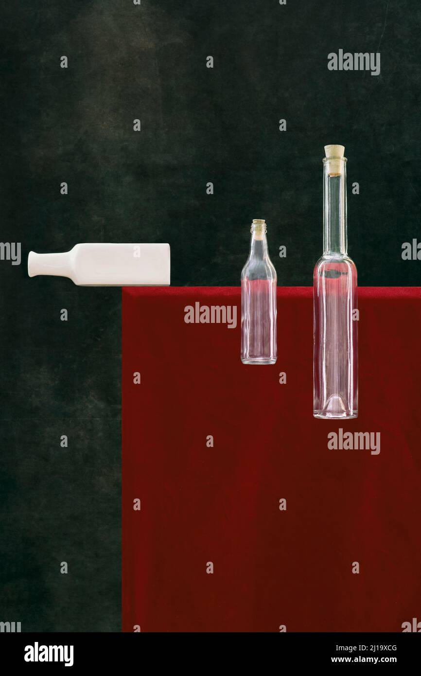 Abstract still life with bottles on the background of a red object ...