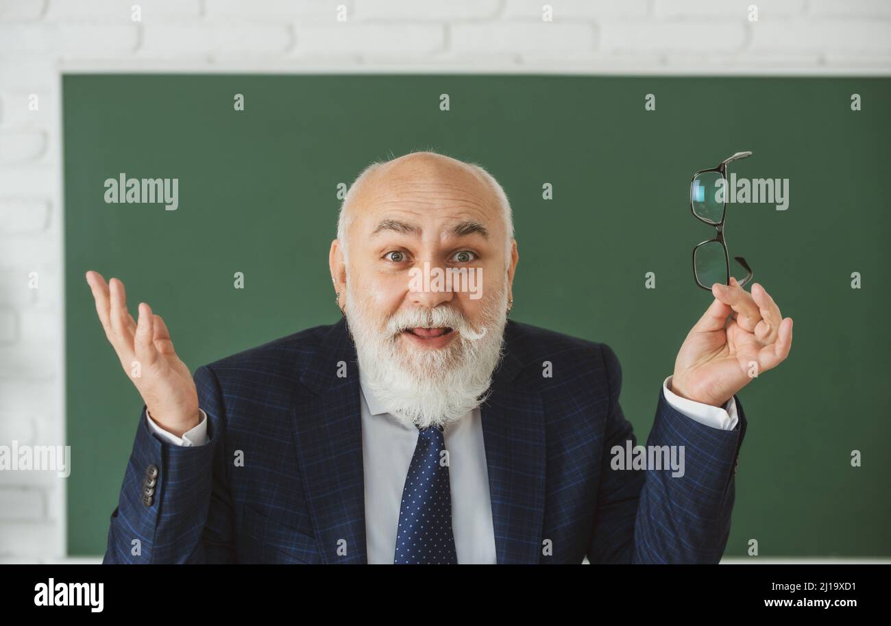 Senior academic professor on lecture near empty blackboard. Knowledge ...