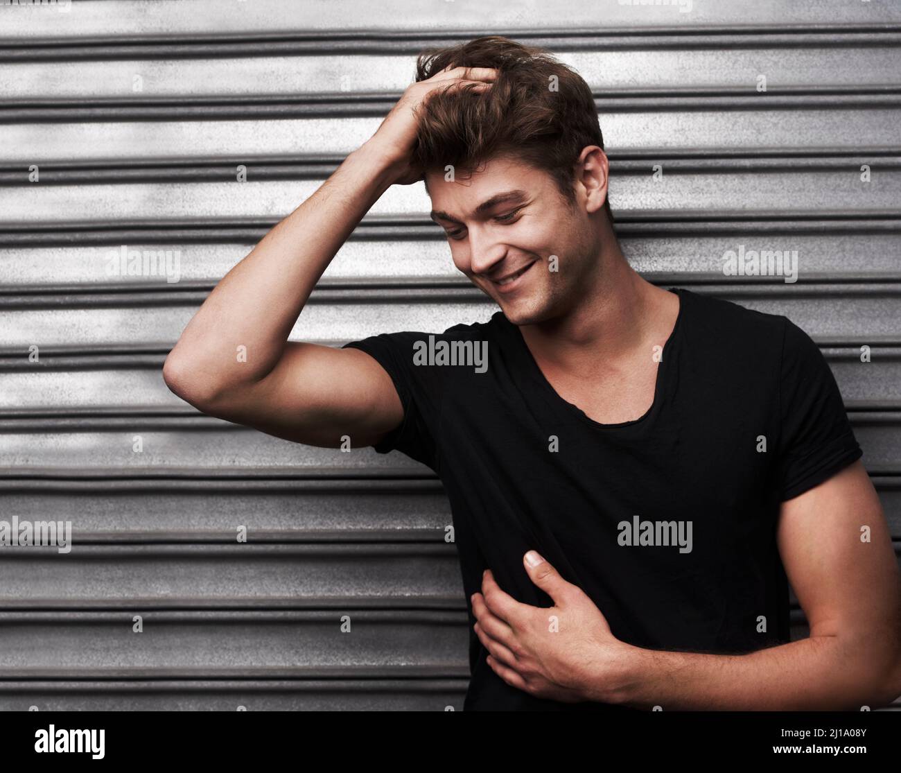 Handsome,stylish and relaxed. Shot of a handsome young man laughing ...