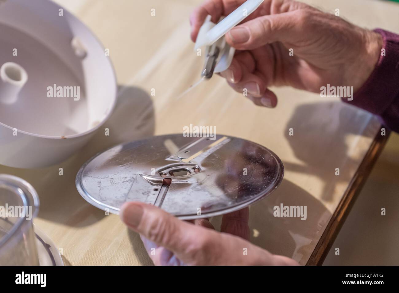 Old man grandpa with hands builds assembled disassembles a kitchen ...
