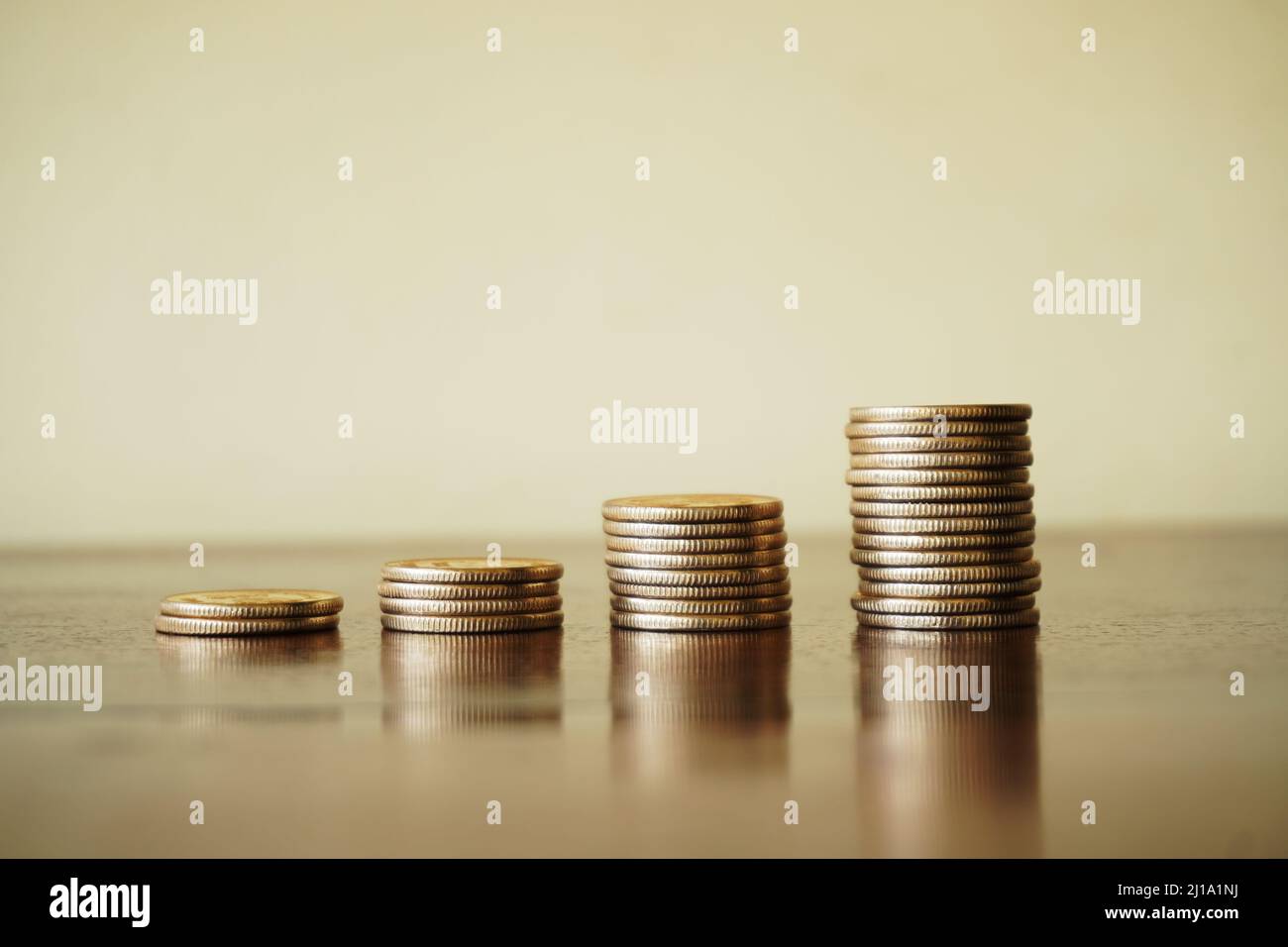 Money growth concept, where small coins in a pile gets bigger and ...