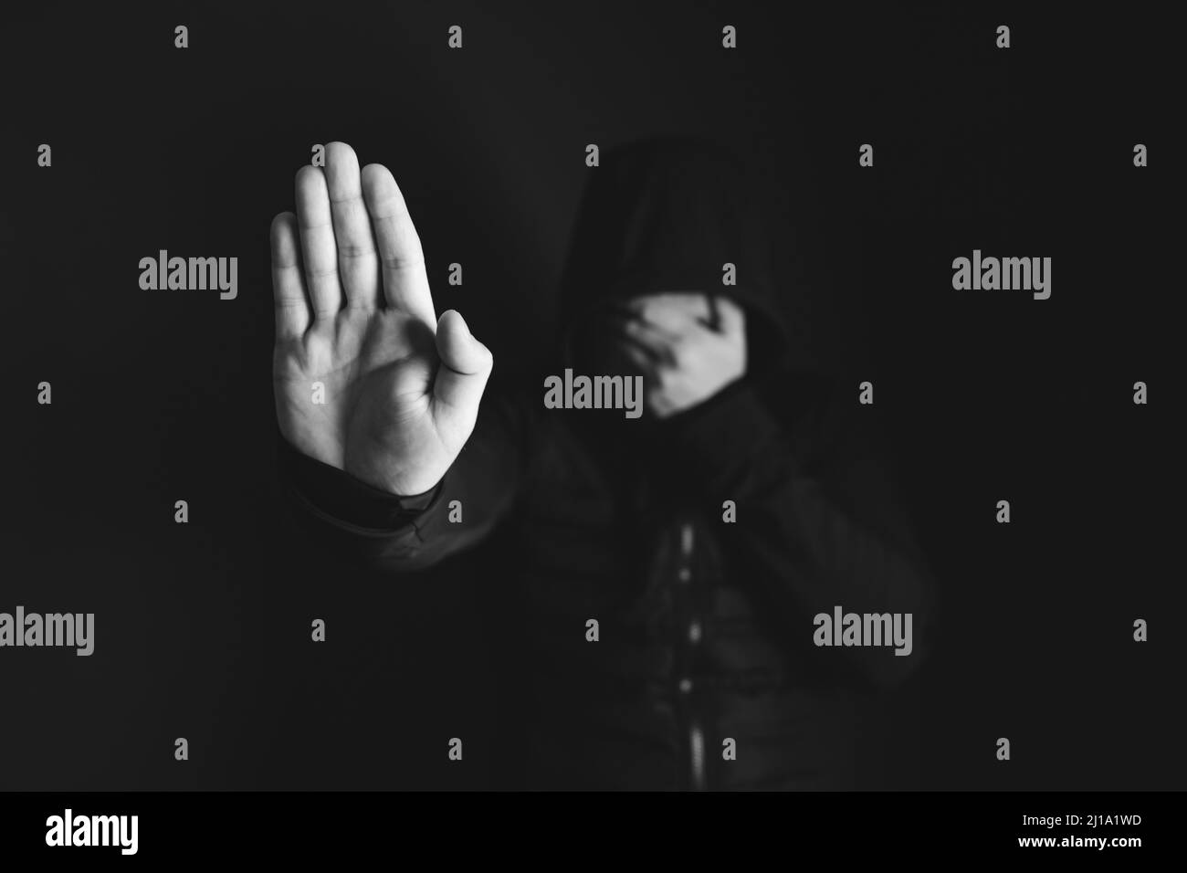 Sad, angry man showing stop sign on dark background. Low key photo ...