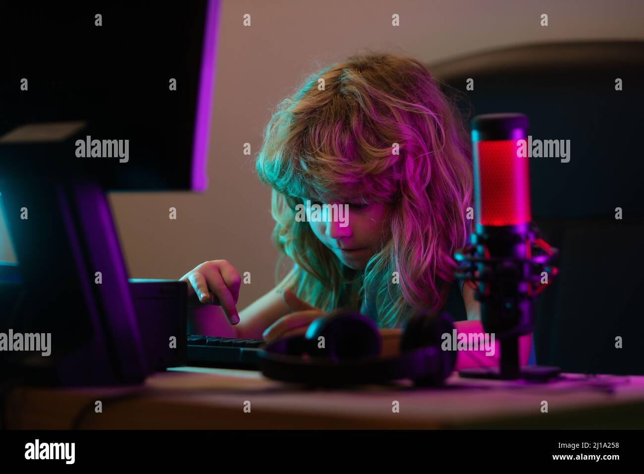 Little child gamer play computer game on desktop. Gaming stream and ...