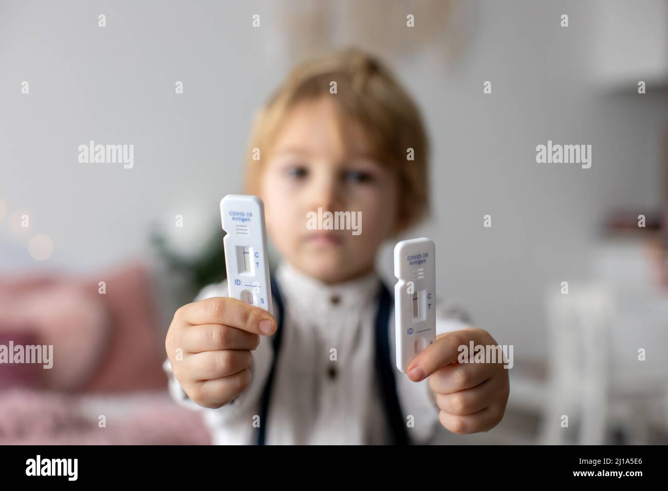 Child, holding two home made covid 19 SWAB antigen test, home allowed ...
