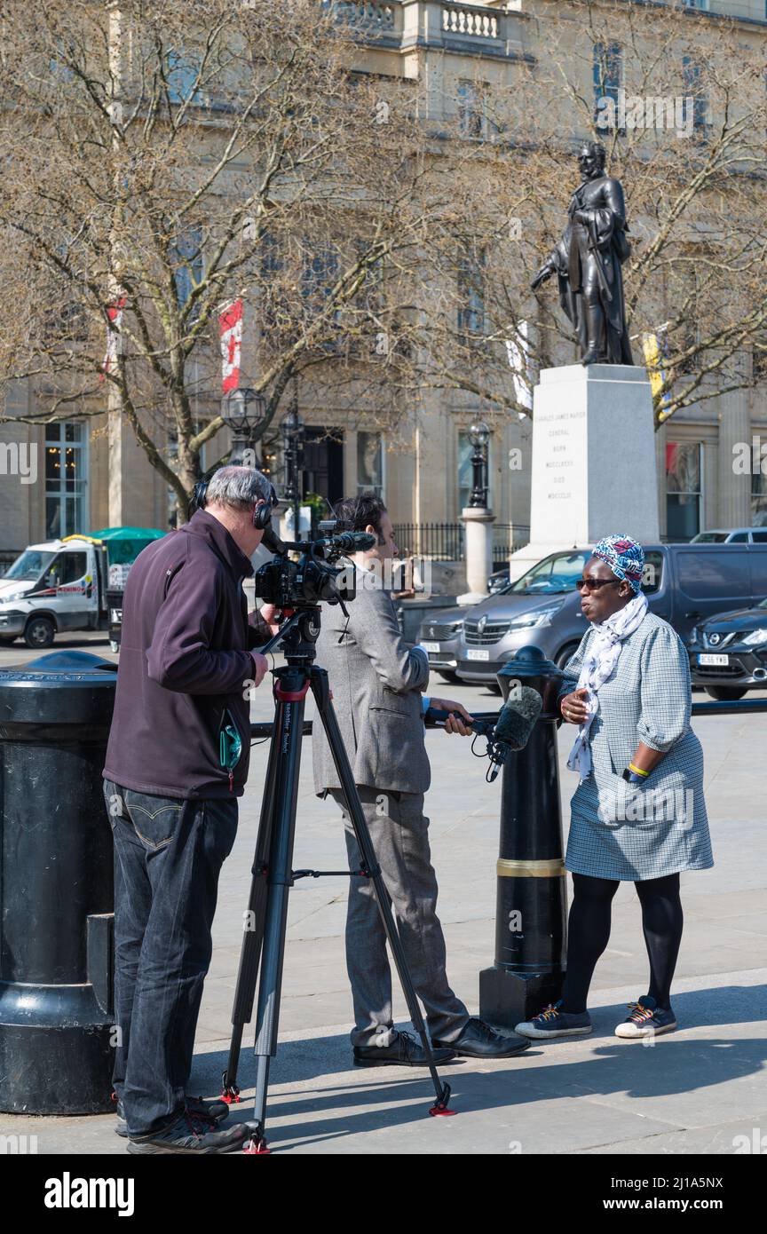 An interview with a black lady being recorded in Trafalgar Square ...