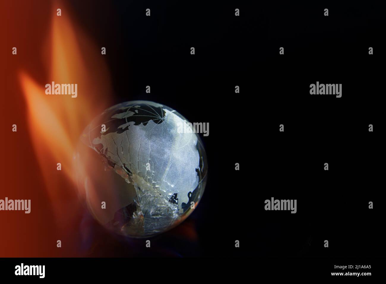 Broken glass planet earth on fire on black background, copy space ...