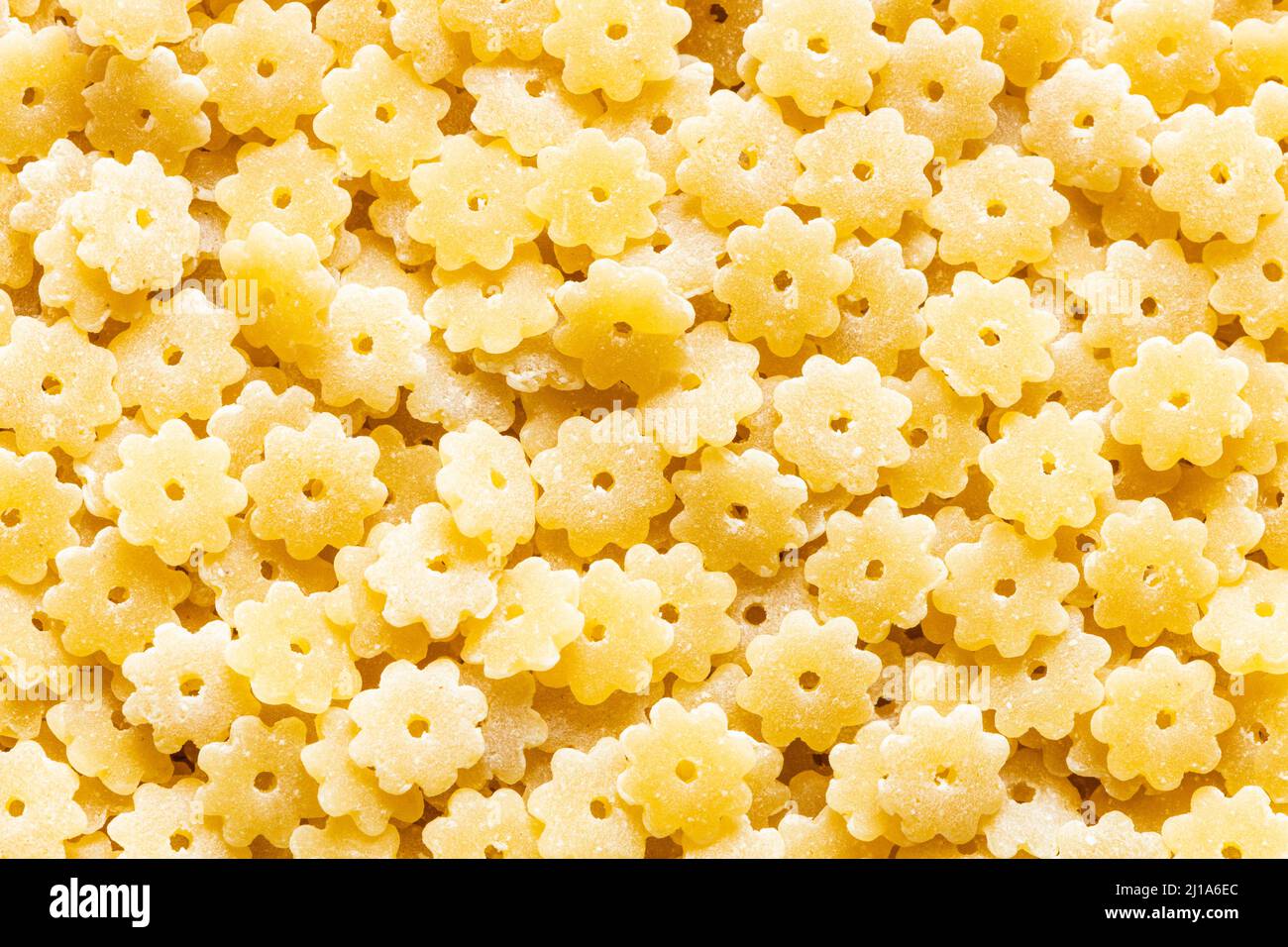 food background from uncooked stelle pasta pieces close up Stock Photo ...