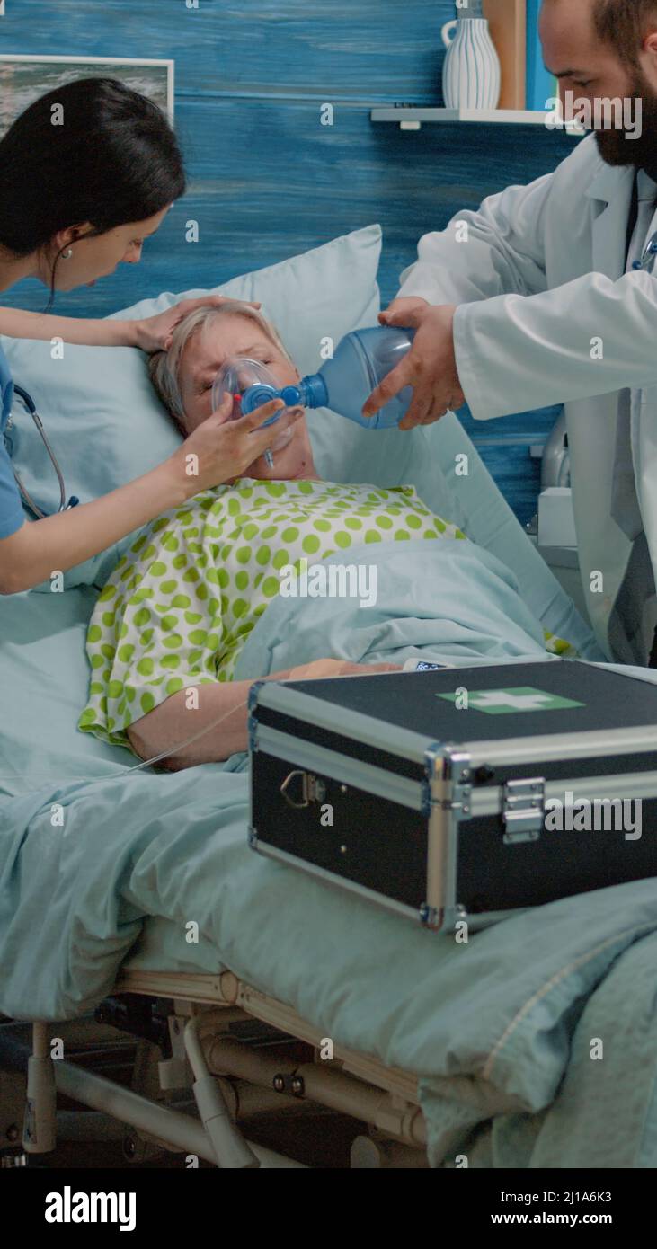 Doctor and nurse using oxygen tube for resuscitation with heart rate ...