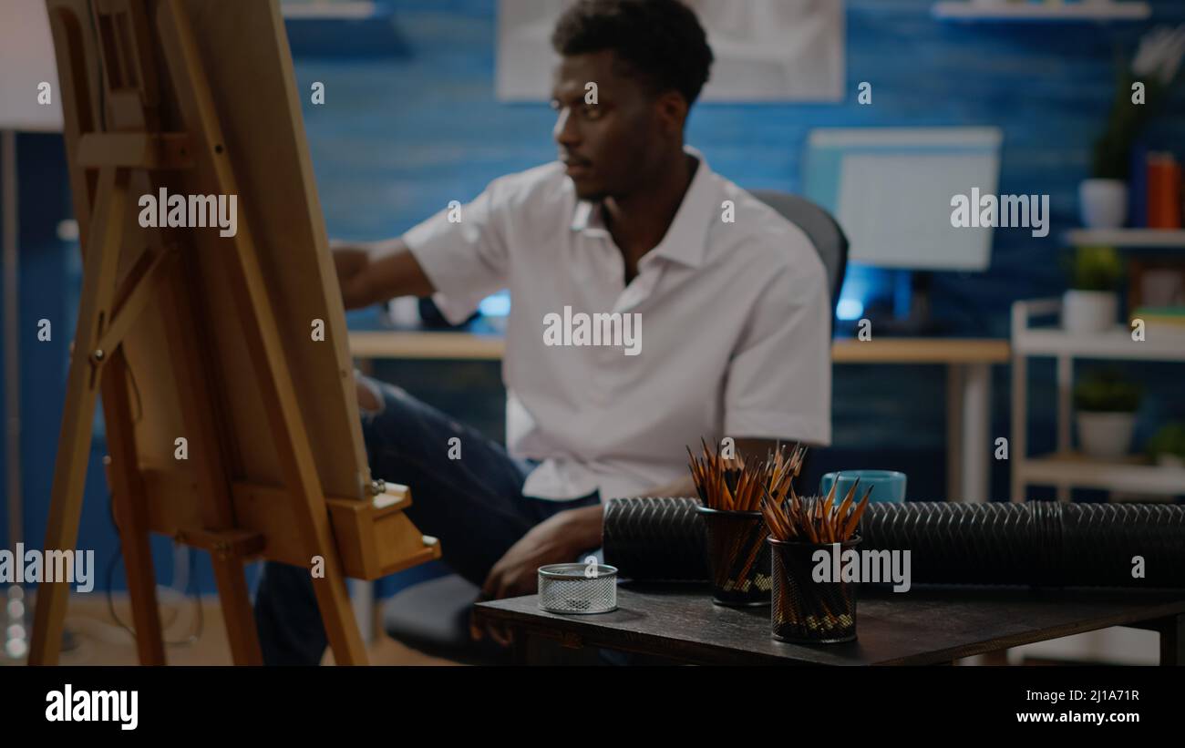 Close up of art instruments on table in artwork room while african ...