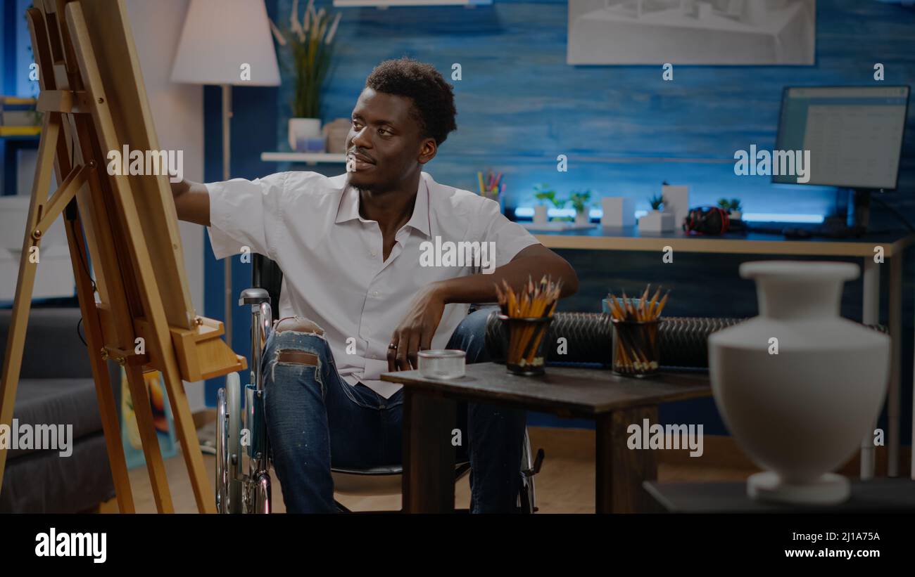 Young black person with disability designing vase drawing on canvas in ...