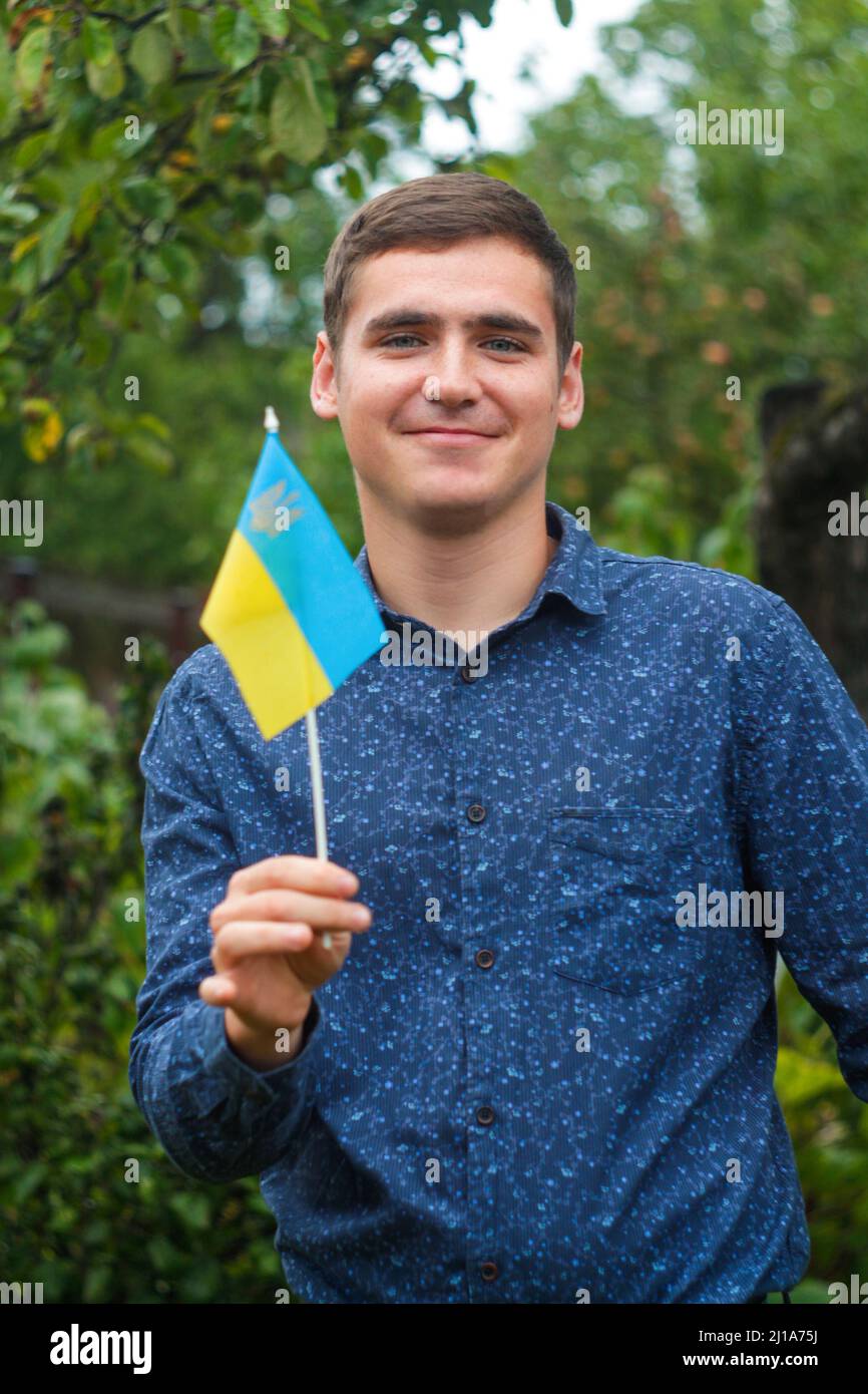 Ukrainian man. Young smiling man holding ukrainian flag. No war ...