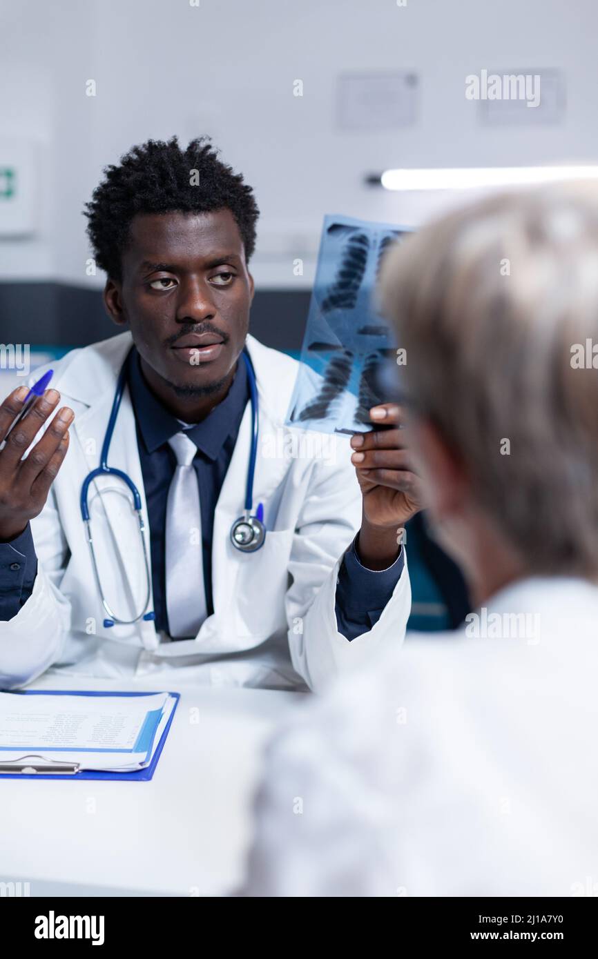 Radiology specialist reviewing senior woman radiography scan image ...