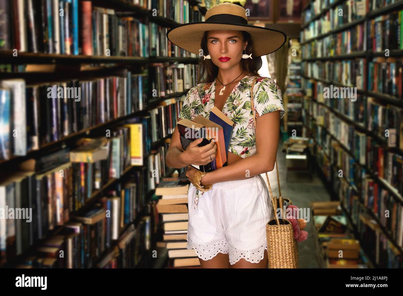 Beautiful girl wearing stylish outfit looking for interesting book in ...