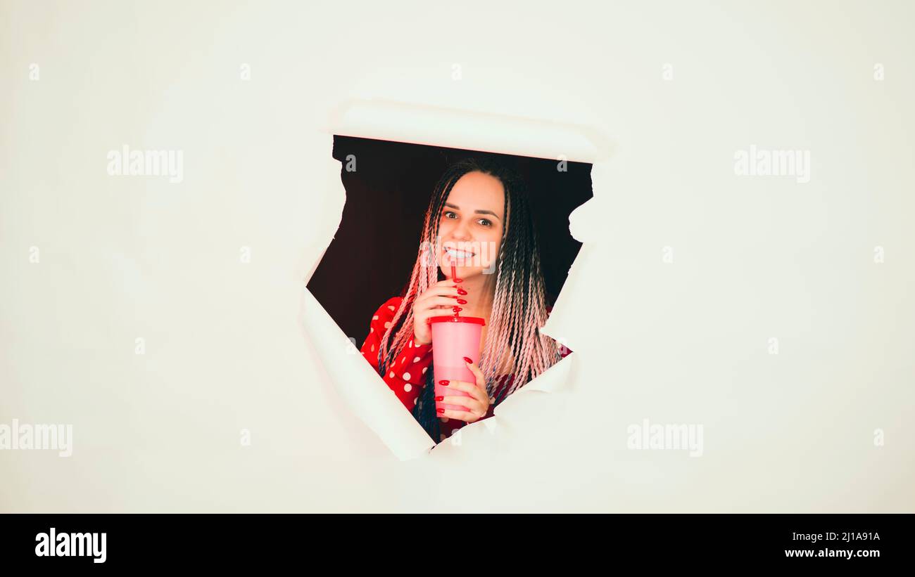 Female bartender with dreadlocks and cup of sweet beverage peeking ...