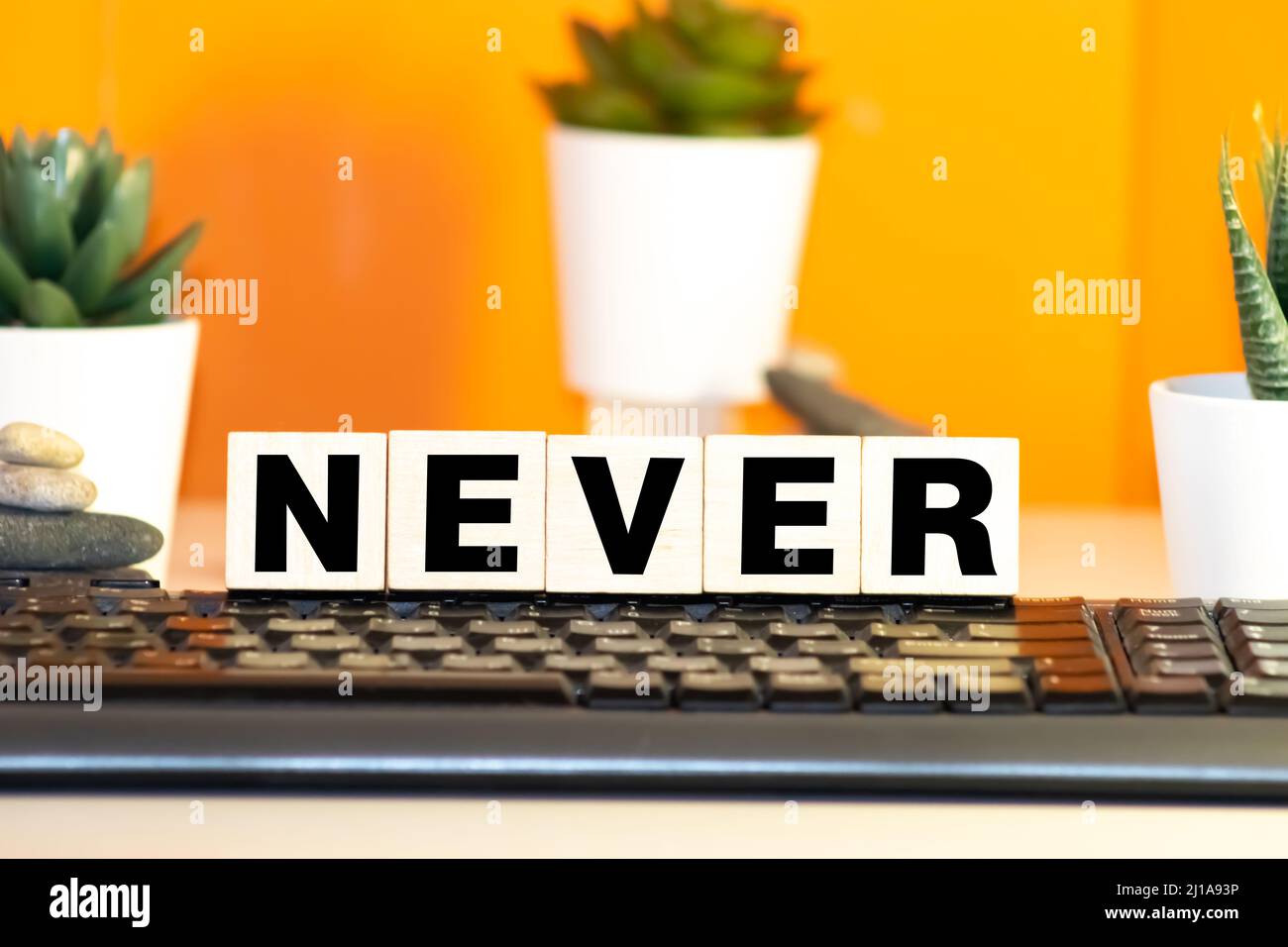 Wooden cubes with word NEVER on blue table. Cubes with blue letters ...