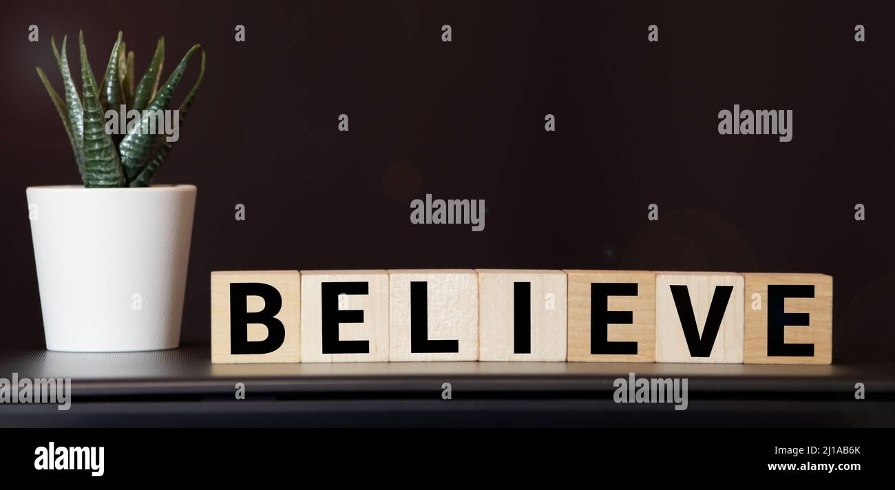believe word written on wood block. believe text on table, concept ...