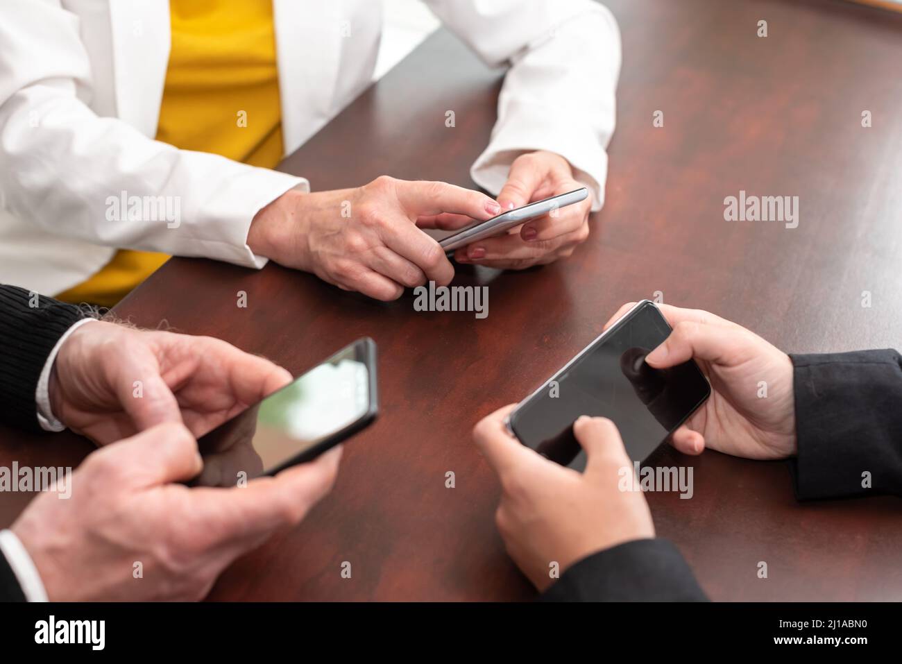 Group of people using and looking at mobile phone together Stock Photo ...