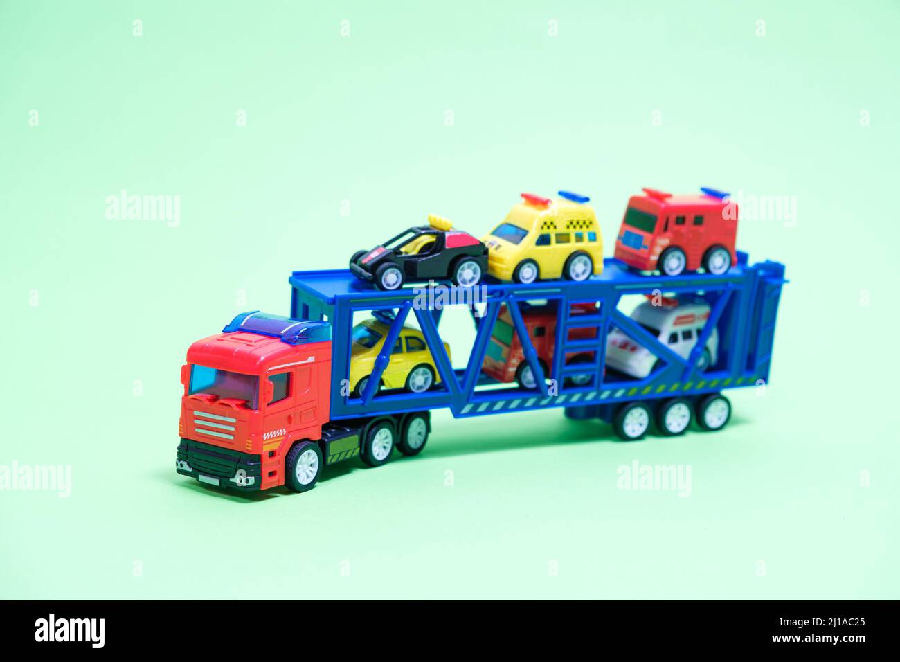 Red toy plastic car transporter with special equipment inside on a ...