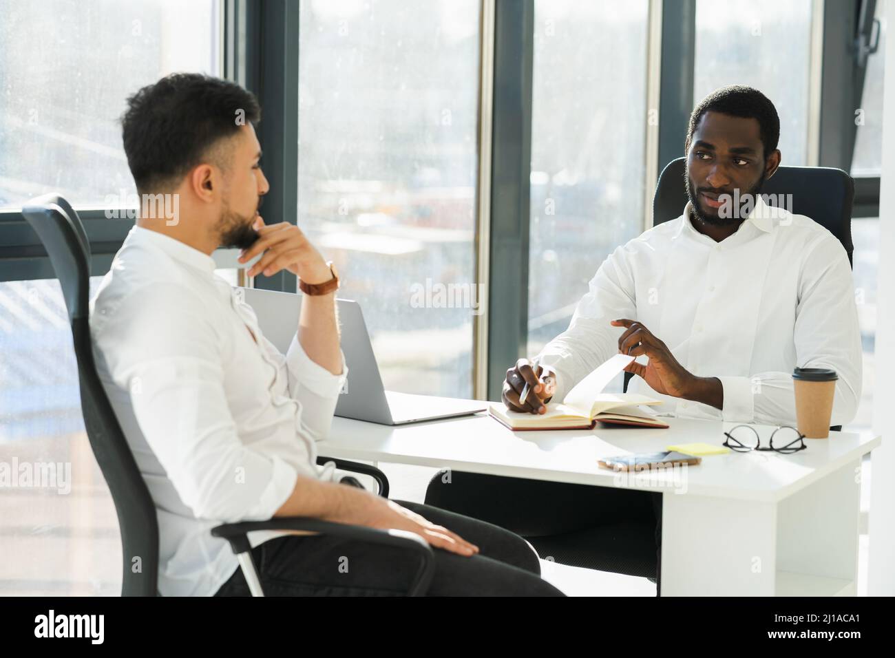 Black man interviewing new employee in company office Stock Photo - Alamy