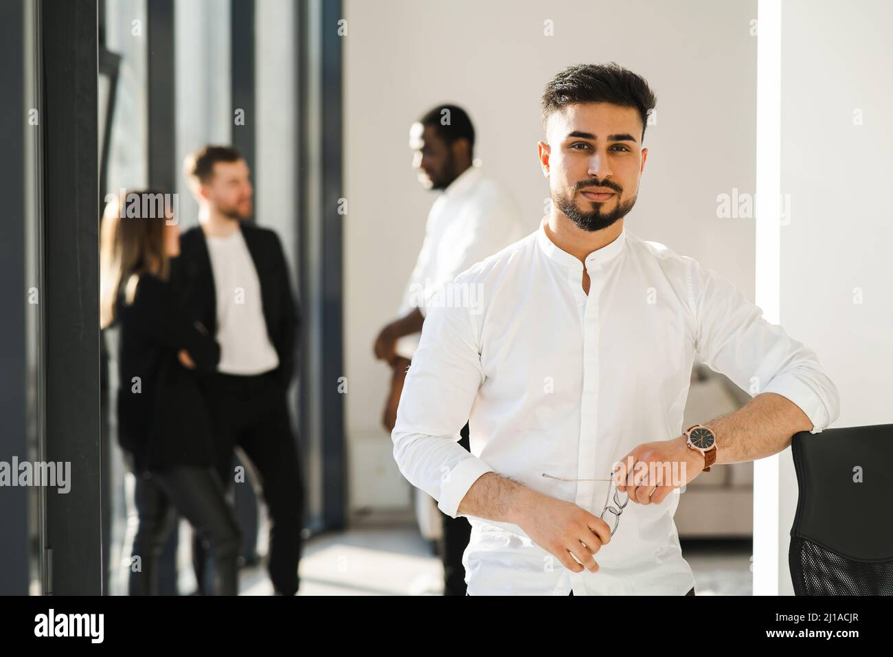 Portrait of a male boss in a white shirt and his employees in the ...