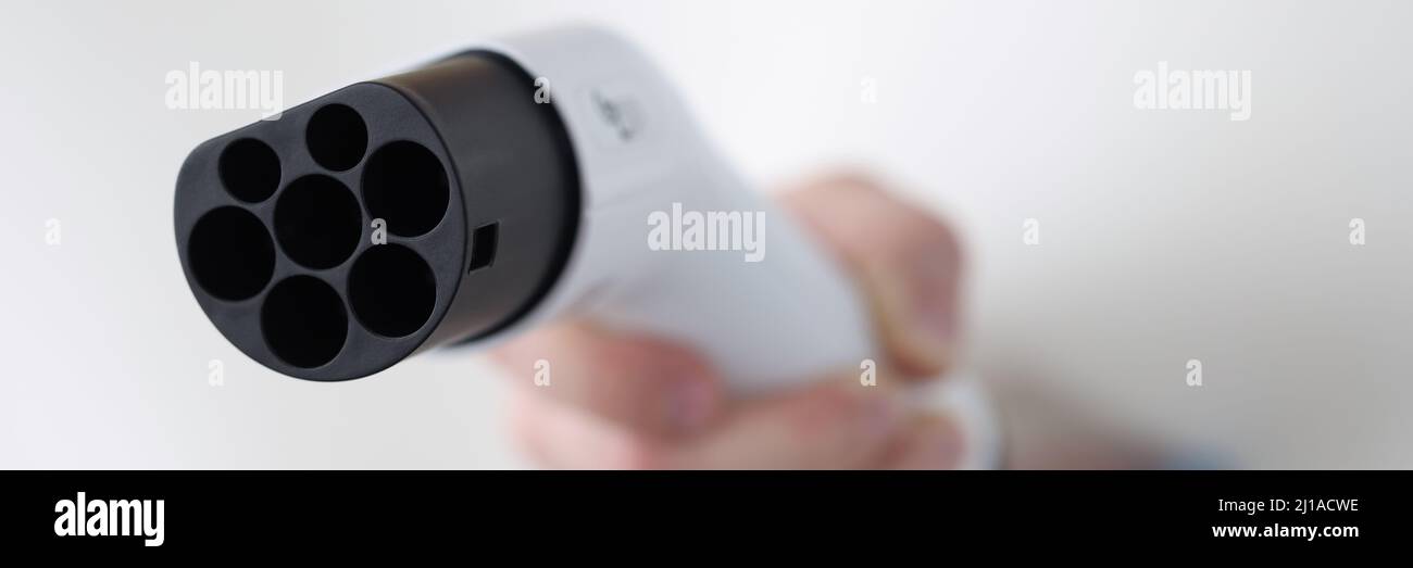 Man hand holding electric wire charge car through paper hole closeup ...