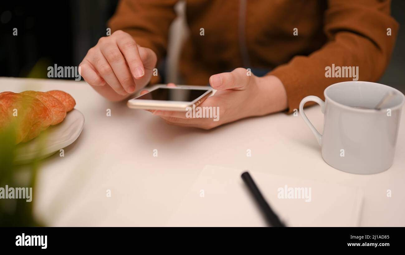 Hand of woman using smartphone on modern white table. typing, text ...