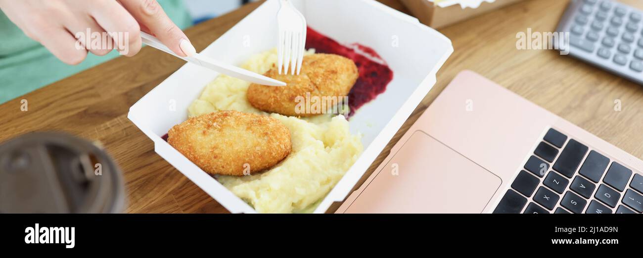 Staff eating cutlets with mashed potatoes from cardboard boxes in ...