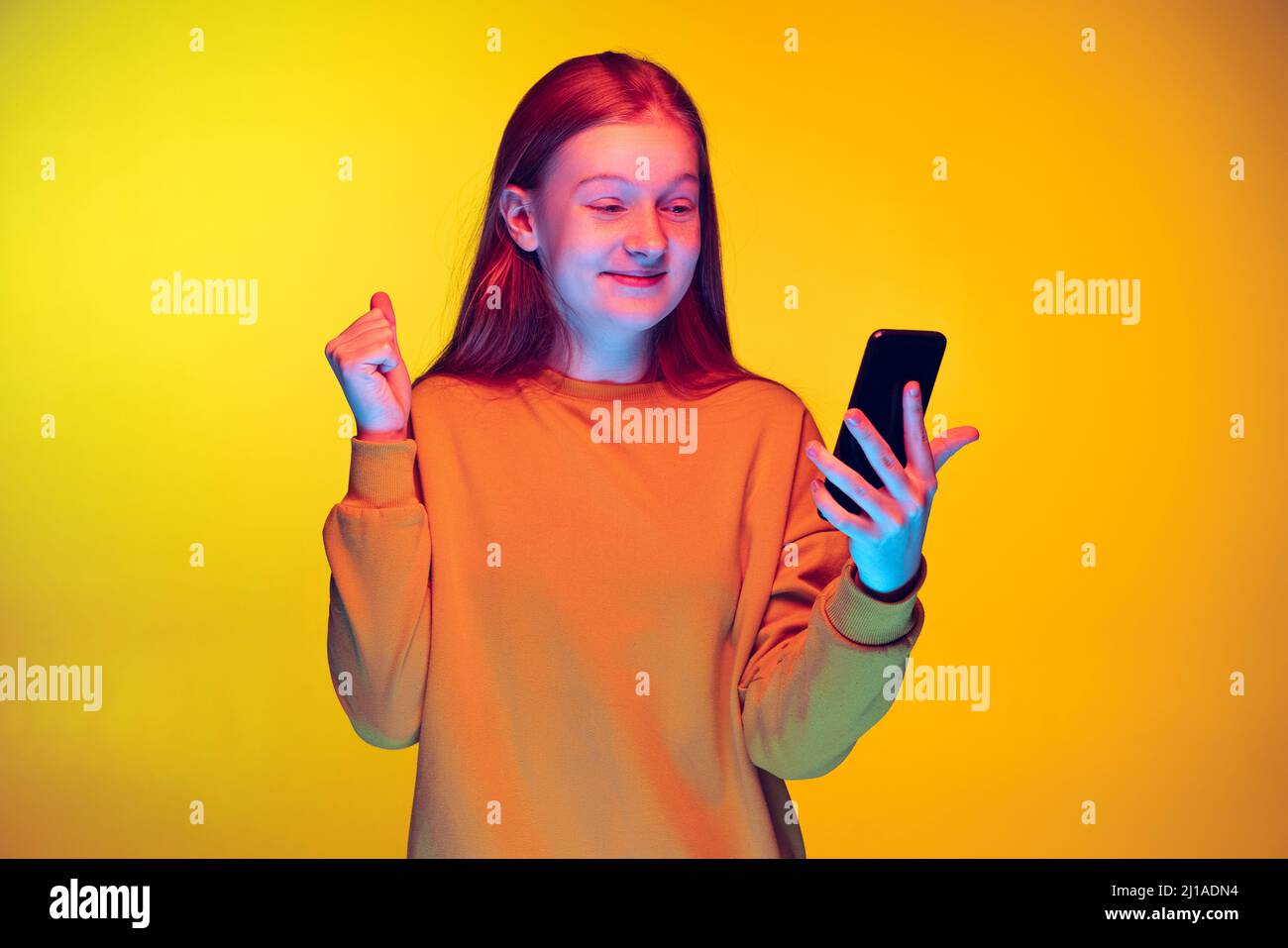 Portrait of young excited girl having online video call on phone ...