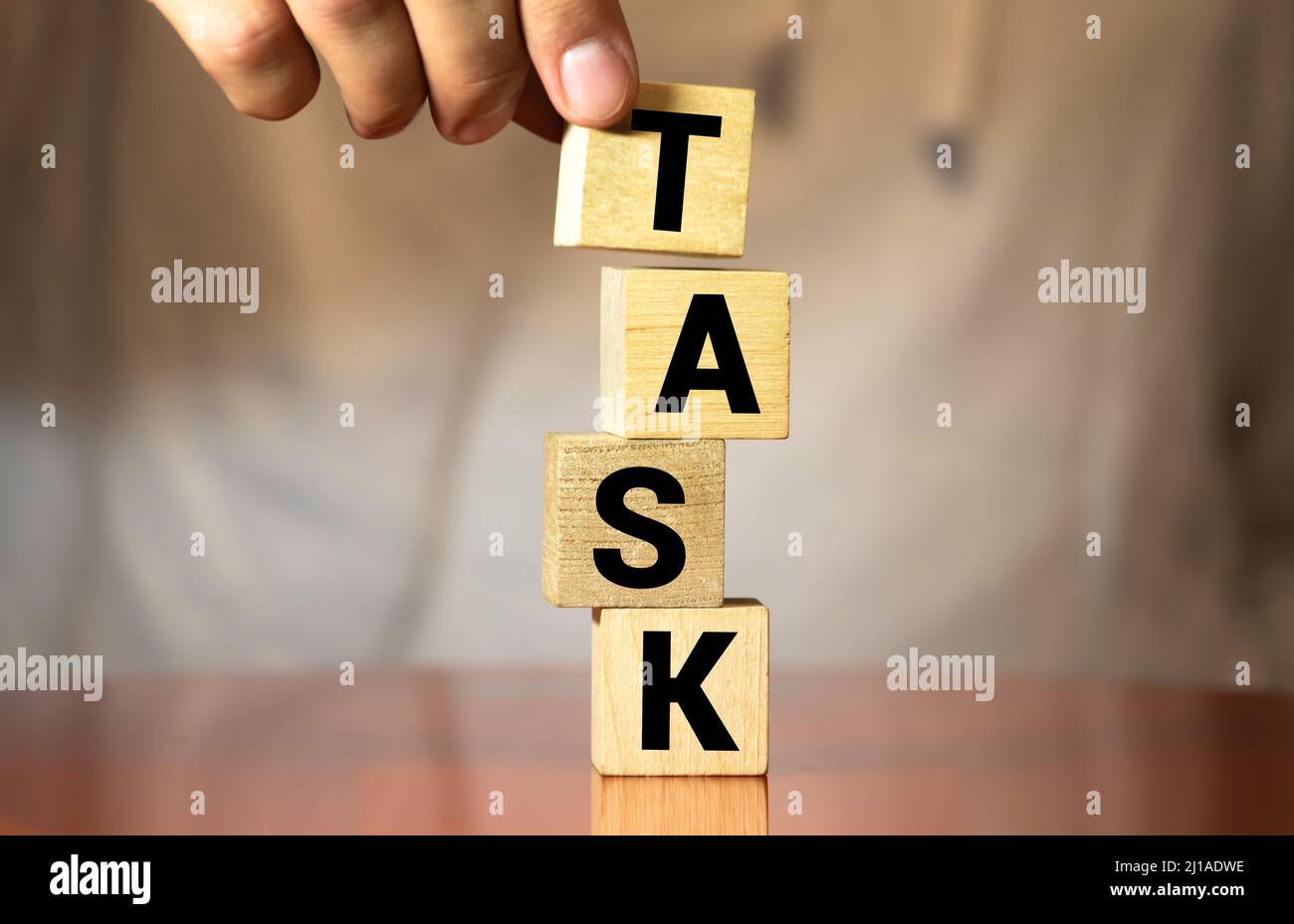 Businesswoman hand holding wooden cube block with TASK business word on ...