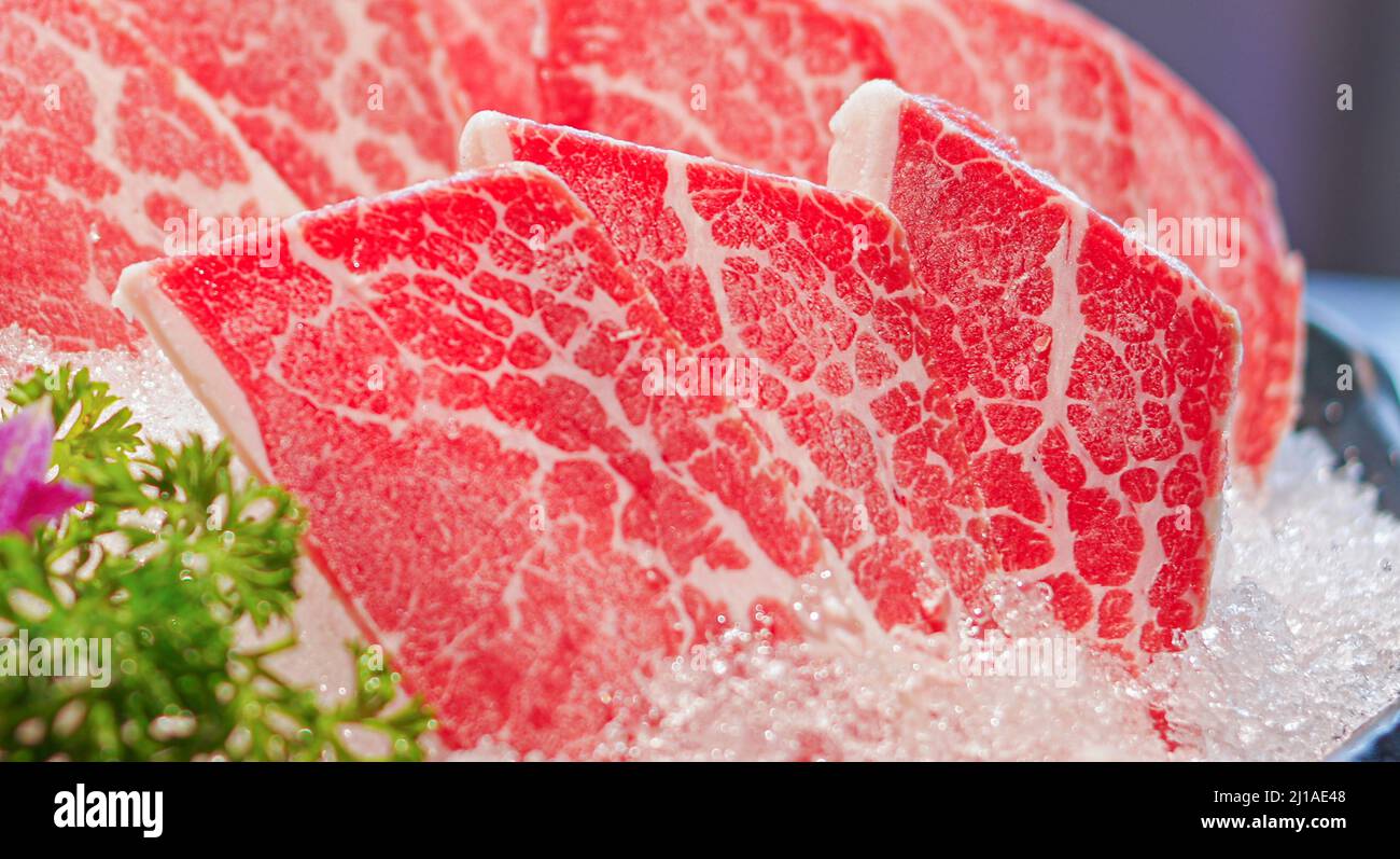 frozen raw wagyu beef slices for hot pot on ice in black bowl Stock ...