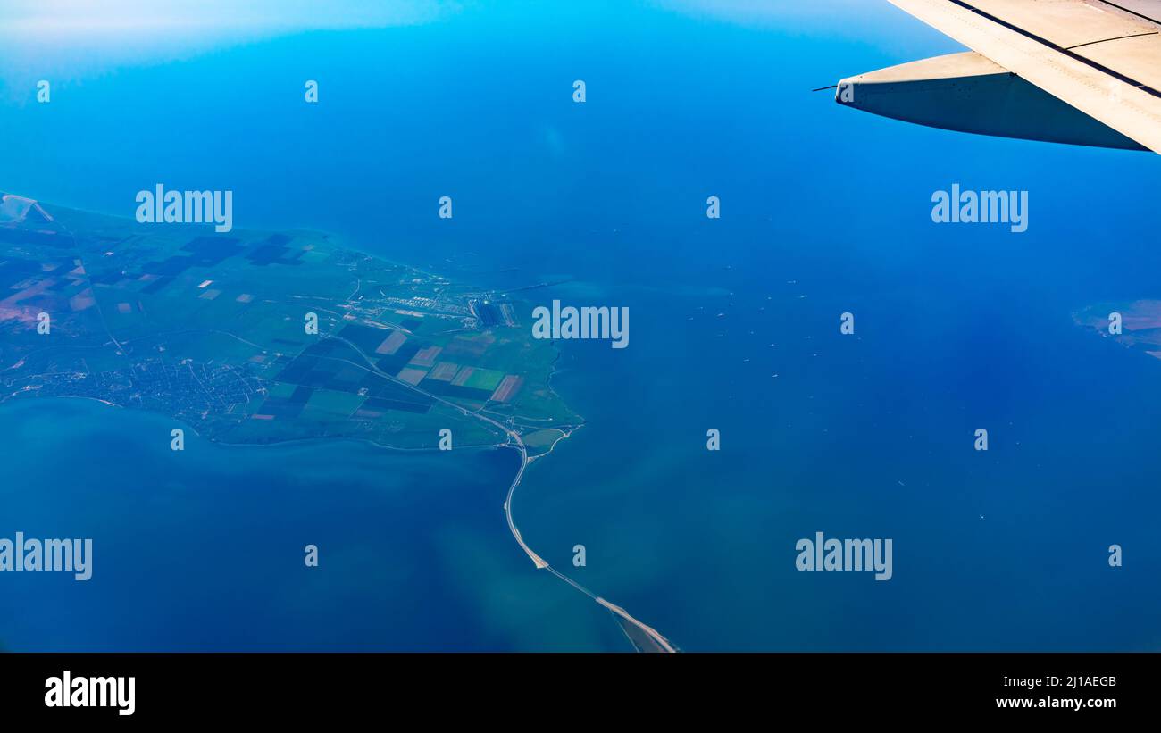 View from the airplane window at a beautiful blue clear sky, earth, sea ...
