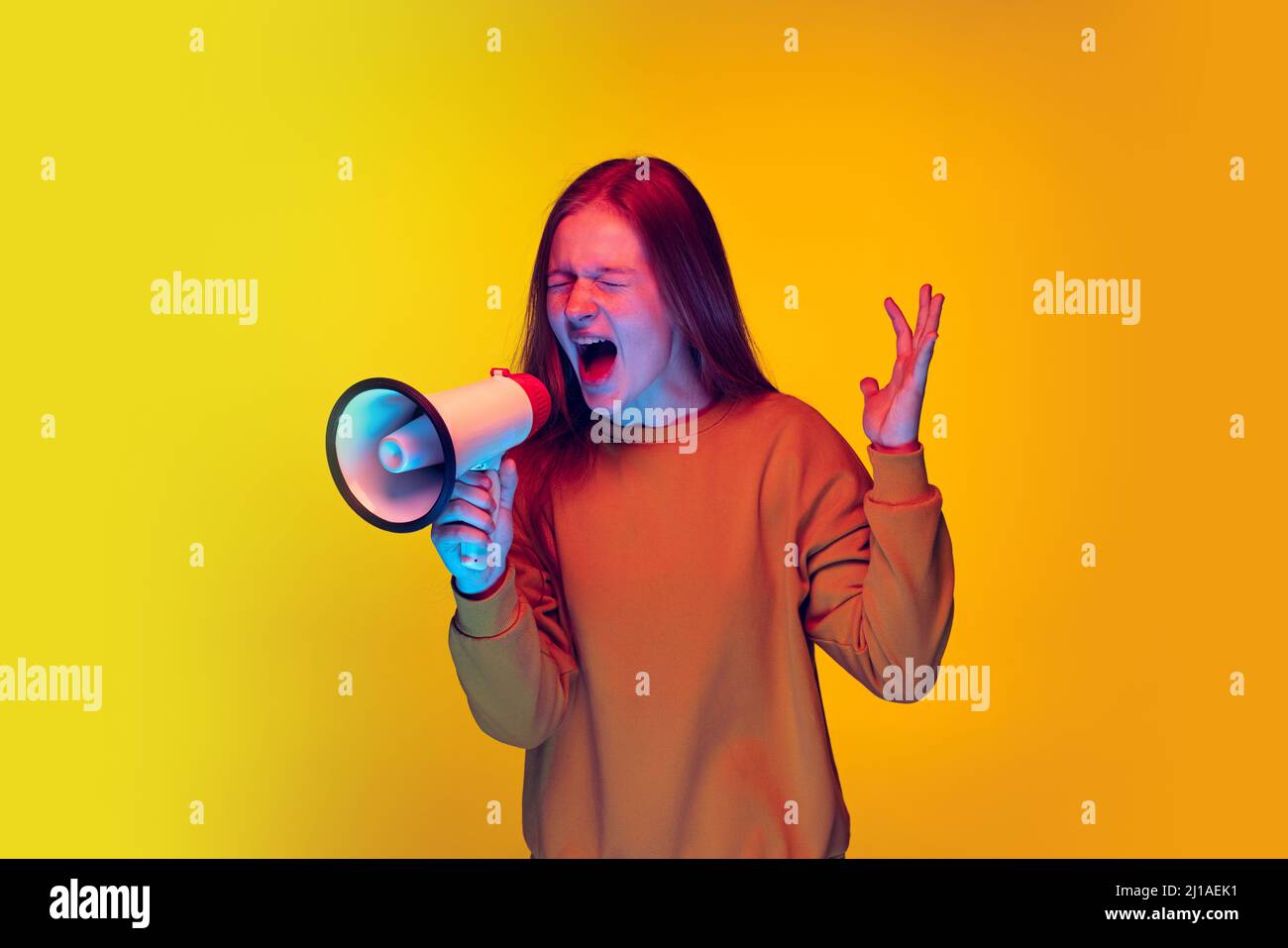 Half-length portrait of young emotive girl expressivelly shouting in ...