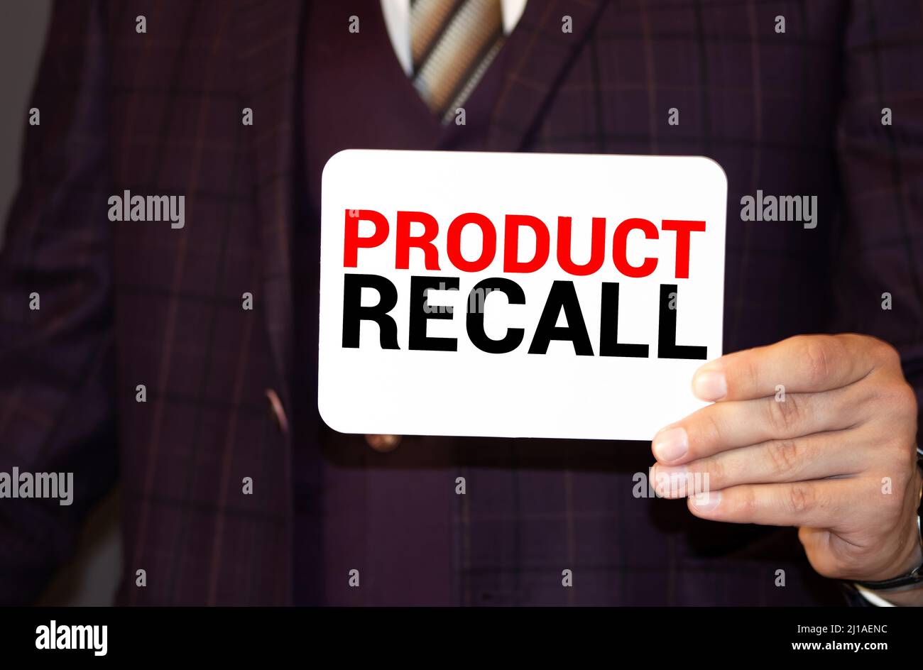 Product Recall. Man holding a card with a message text written on it ...