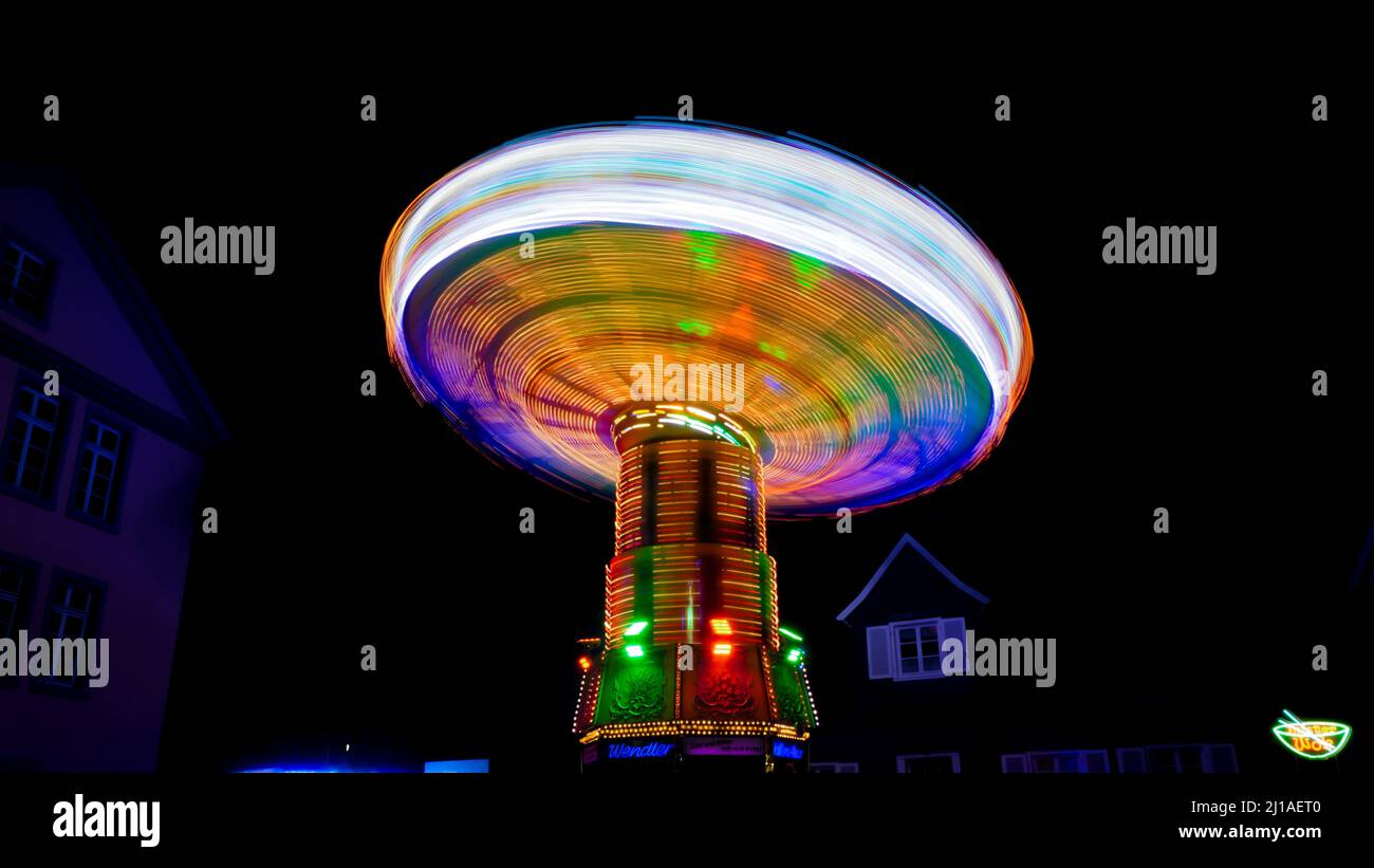 Chain carousel at a funfair by night in motion blur Stock Photo - Alamy