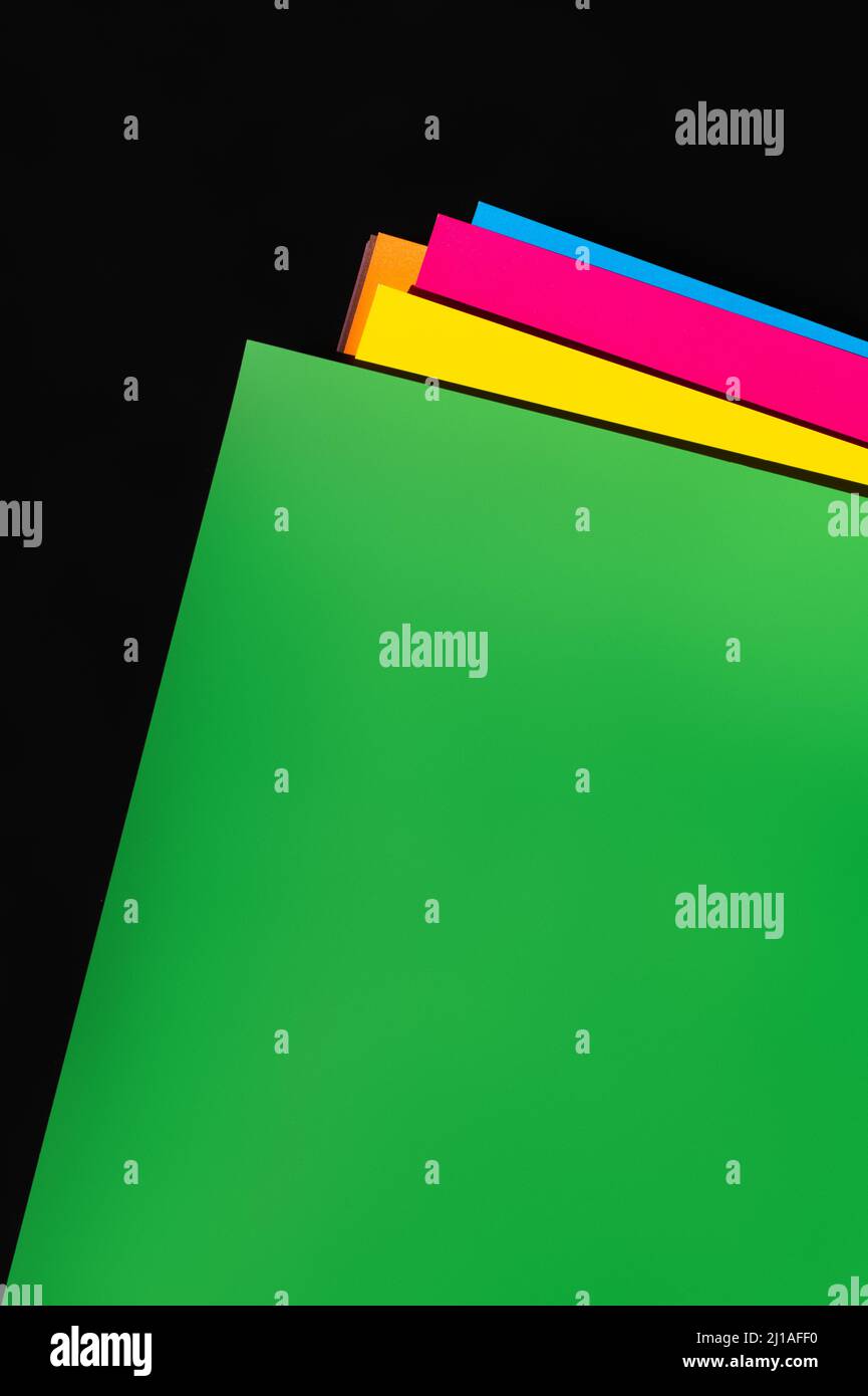 bright multicolored paper sheets on black background Stock Photo - Alamy