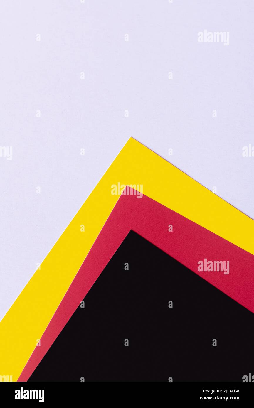 black, red and yellow paper sheets on light lavender background Stock ...
