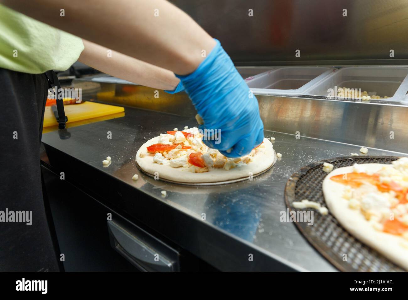 Chef preparing pizza on metal table, closeup. Closeup hand of chef ...