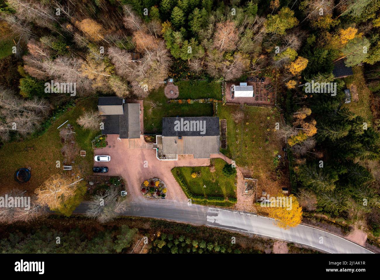 Aerial view above a house in middle of autumn color trees - top down ...