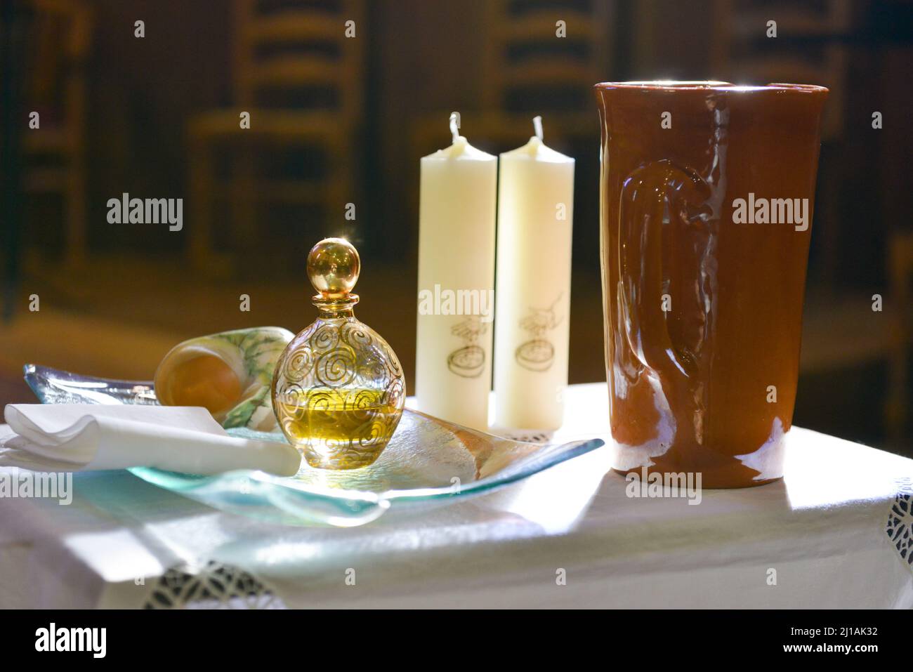 Items prepared on a table for a baptism ceremony in a church, backlit ...