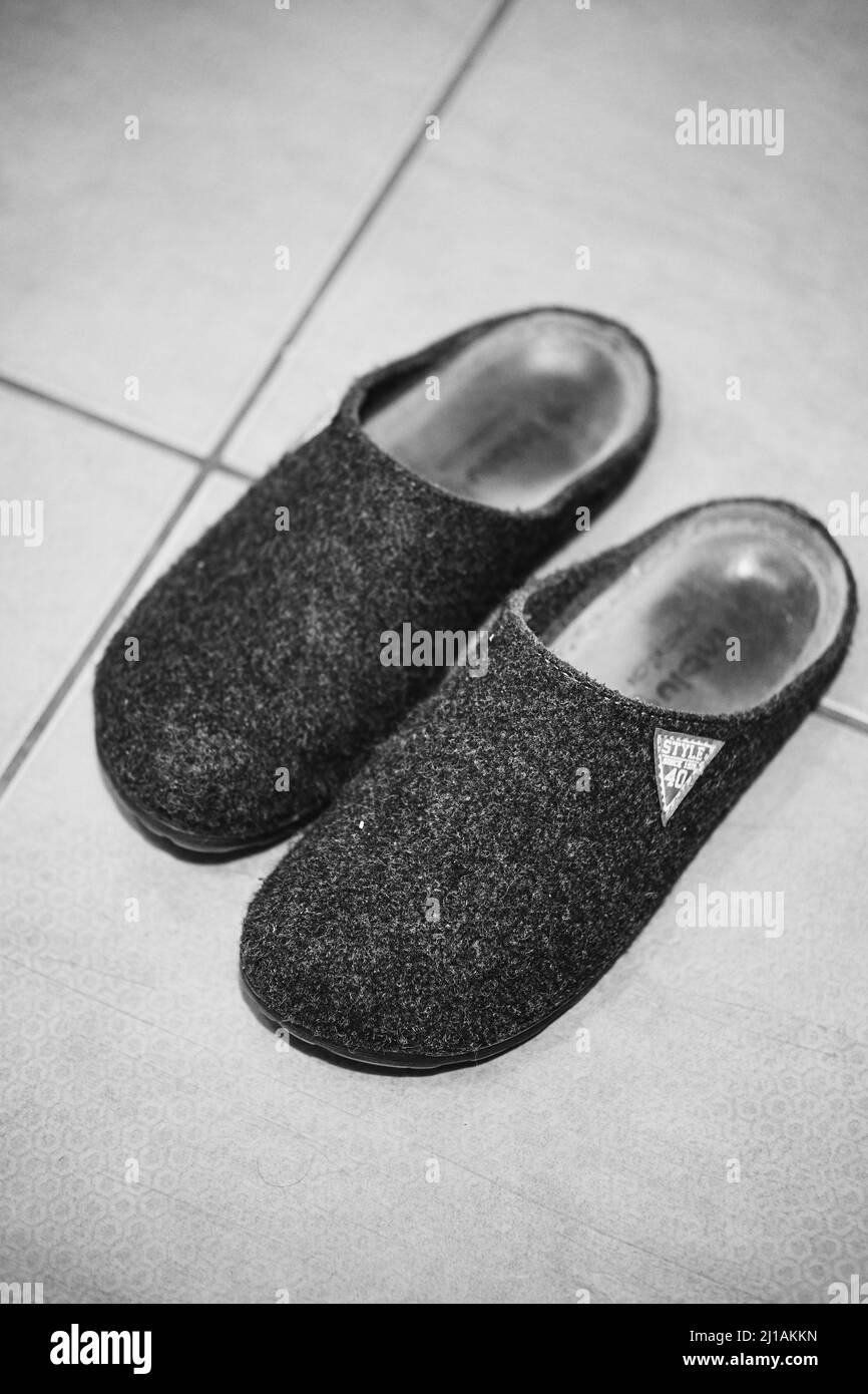 A pair of casual home shoes on a tile floor in black and white Stock ...