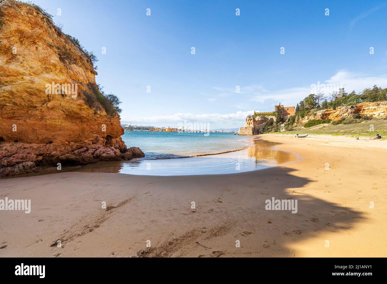 Coastline with sandy beach and castle by Arade river in Ferragudo ...
