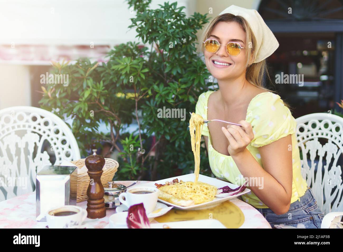 Happy young woman eating pasta in Italian restaurant Stock Photo - Alamy